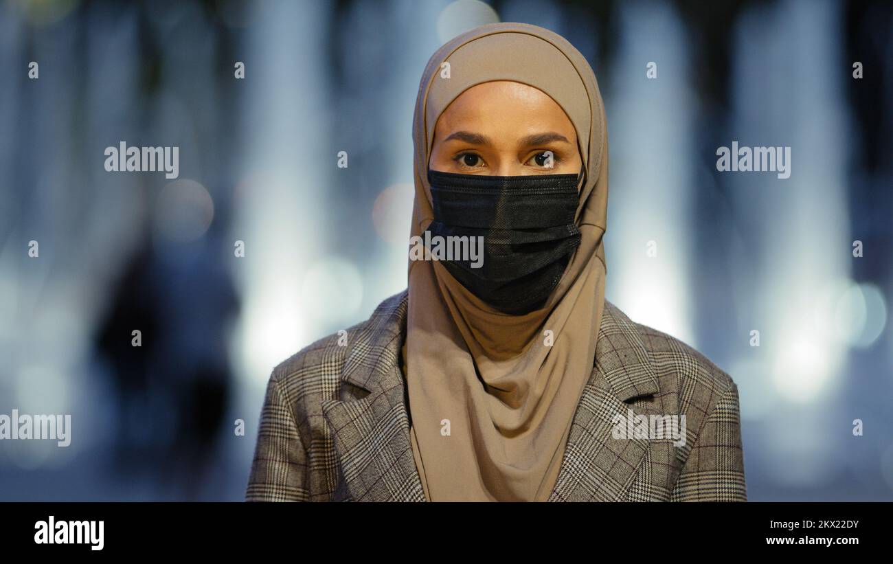 Close-up islamic female in medical mask posing in night city. Muslim ...