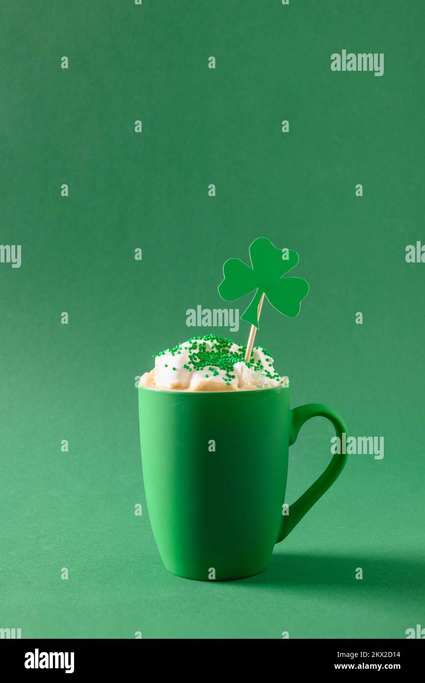 Irish coffee in green cup with whipped cream and sprinkles for St ...