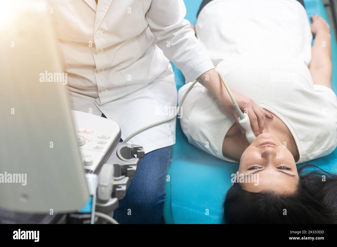 Doctor using ultrasound scanning machine for examining a thyroid of ...