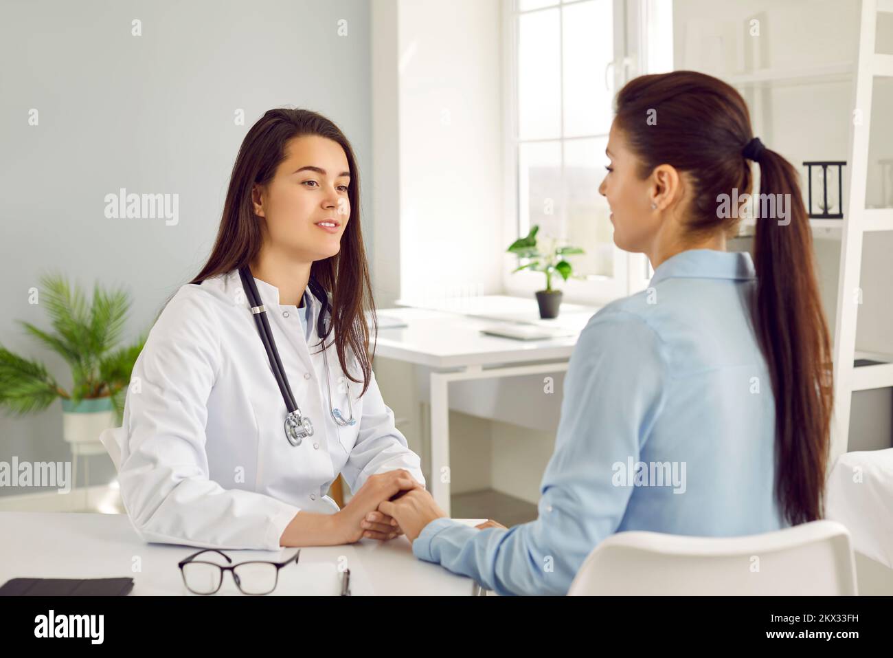Young Caucasian woman doctor in white coat comforting patient hospital ...