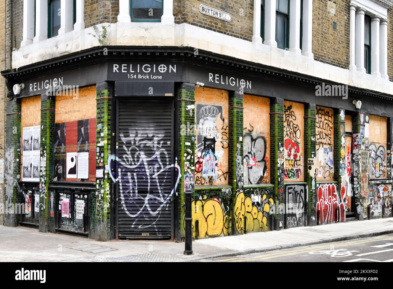 Religion shop with boarded up windows and shutters covered in graffiti ...
