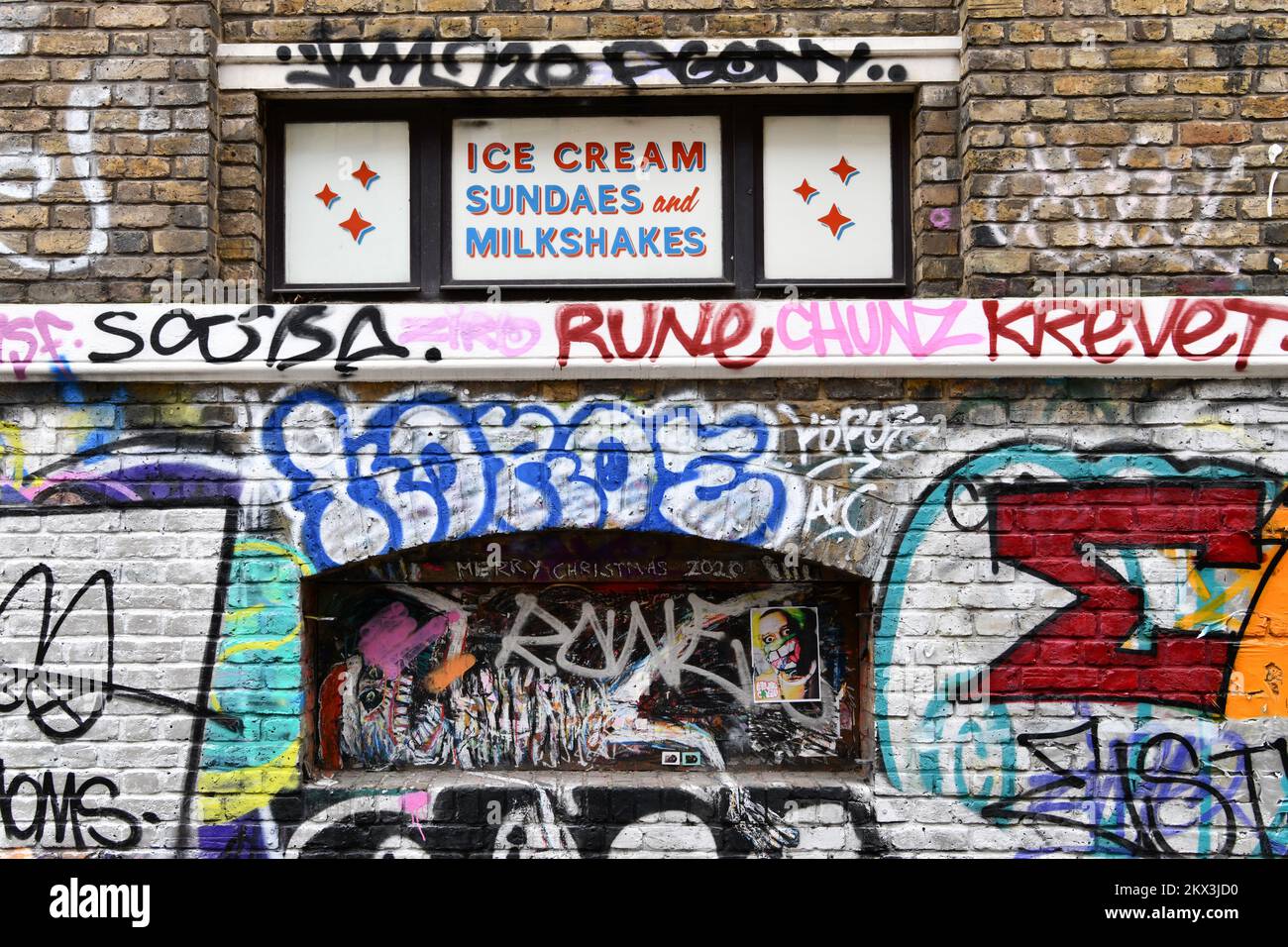 Graffiti underneath sign saying ice cream sundaes and milkshakes on ...