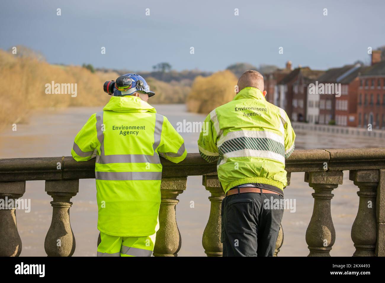 Rear view of two Environment Agency workers looking out over the River ...