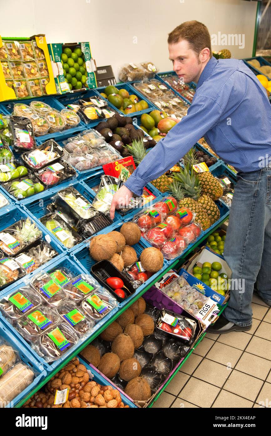 netherlands, a customer chooses tropical fruit from the offered fruits ...