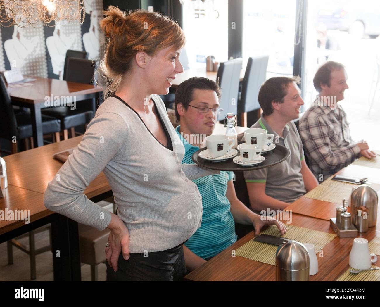 Netherlands, pregnant waitress is going to serve coffee Stock Photo - Alamy