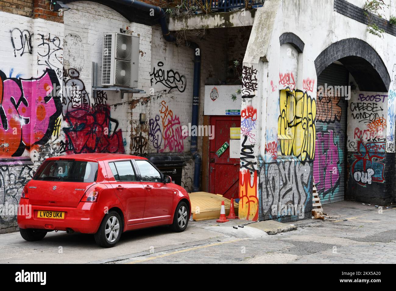 Red Suzuki Swift car in graffiti covered yard in Shoreditch London ...