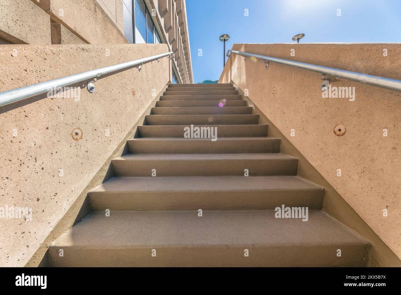 View from the bottom of staircase outside a building with blue sky and ...