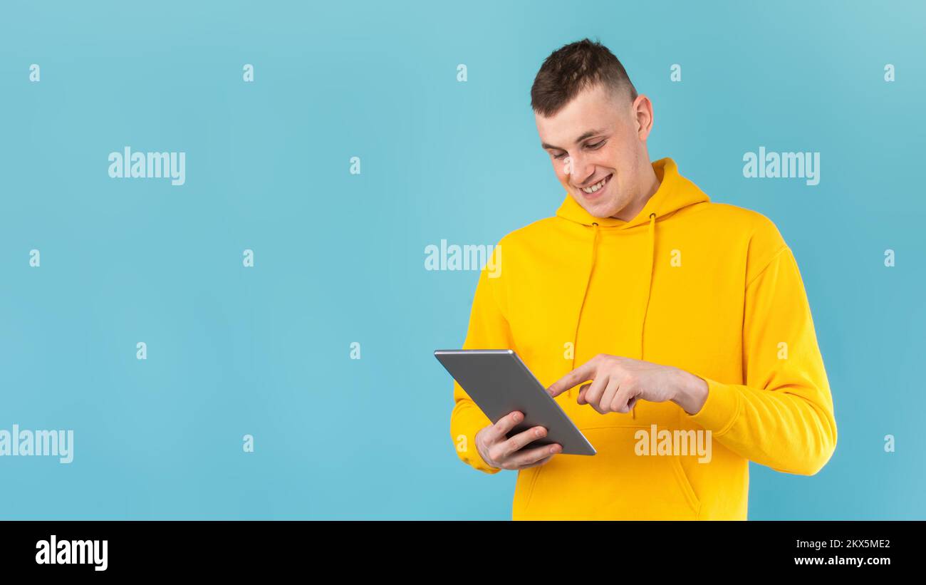 Modern technologies concept. Young man browsing web on digital tablet ...