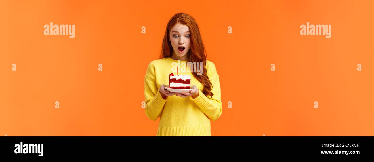 Girl making wish, receive birthday cake with one candle, celebrating b ...