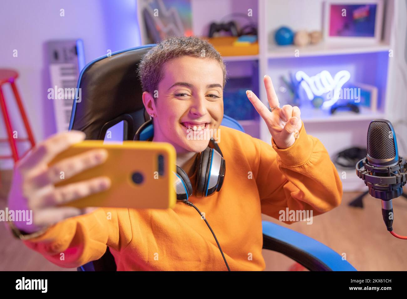 Gamer girl with short haircut taking a selfie playing online games and ...