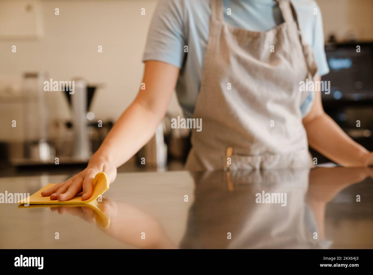 Young barista woman wearing apron cleaning desk in cafe Stock Photo - Alamy