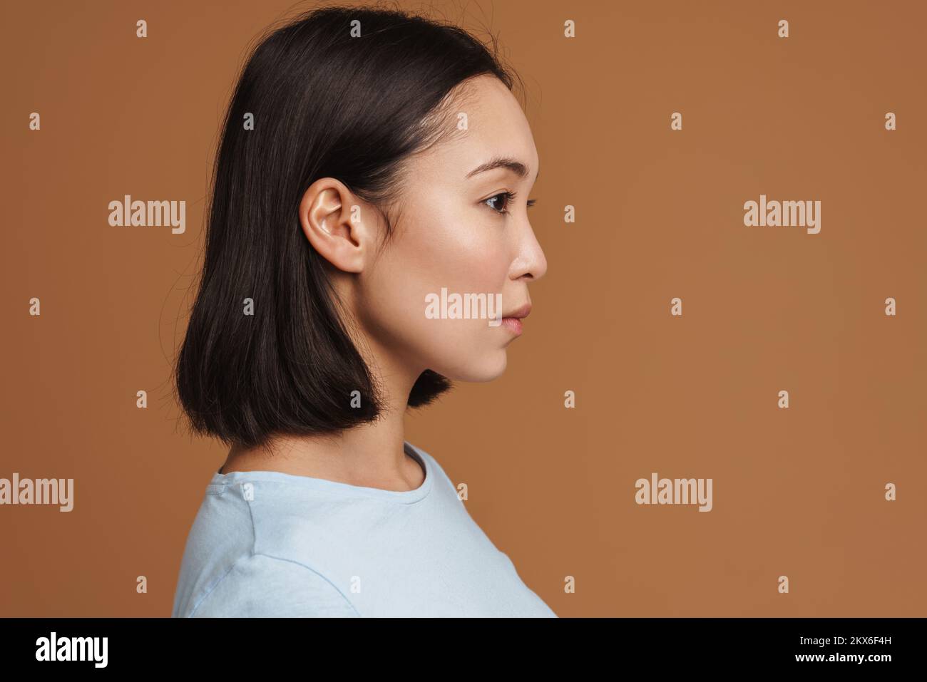 Young asian woman looking aside while posing in profile isolated over ...