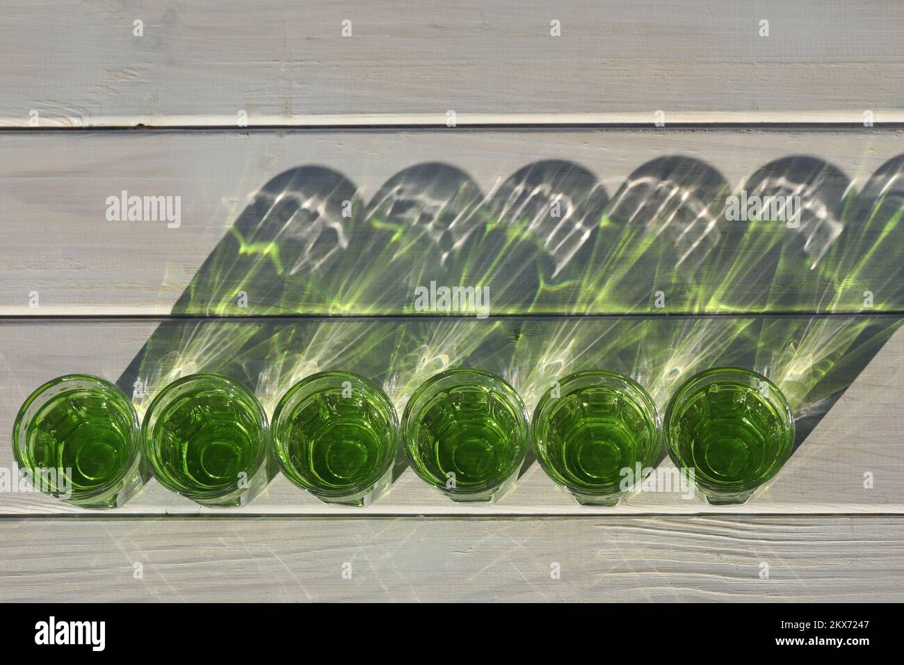 green absinthe drink pattern on the white wooden background with copy ...