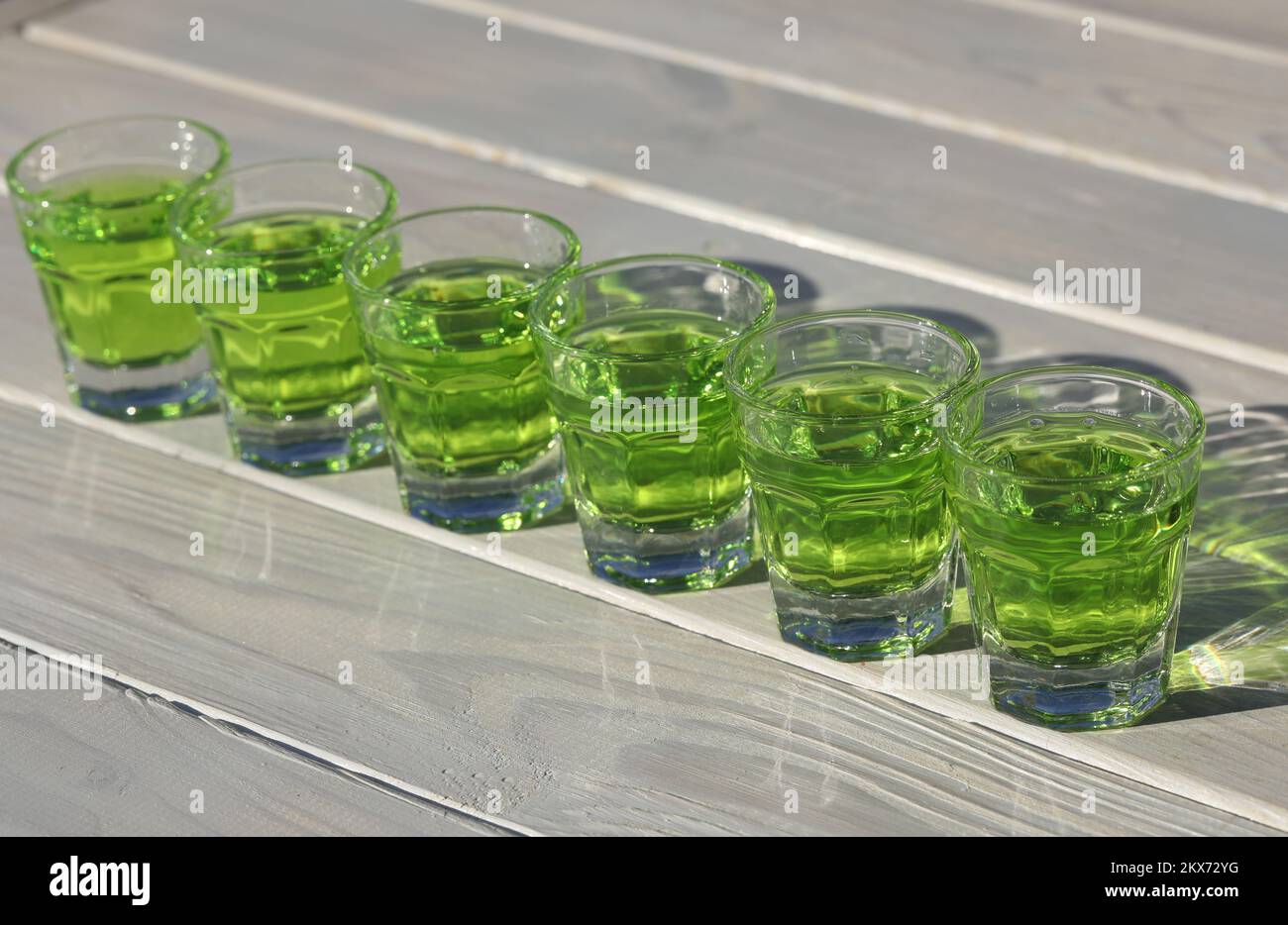 green absinthe drink pattern on the white wooden background with copy ...