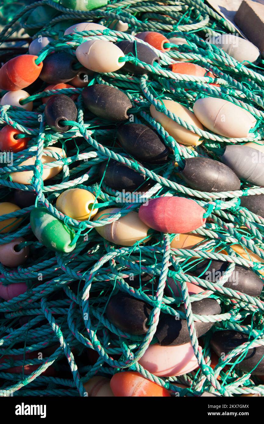 Nylon ropes with buoys from fishing nets in a pile on the waterfront of ...