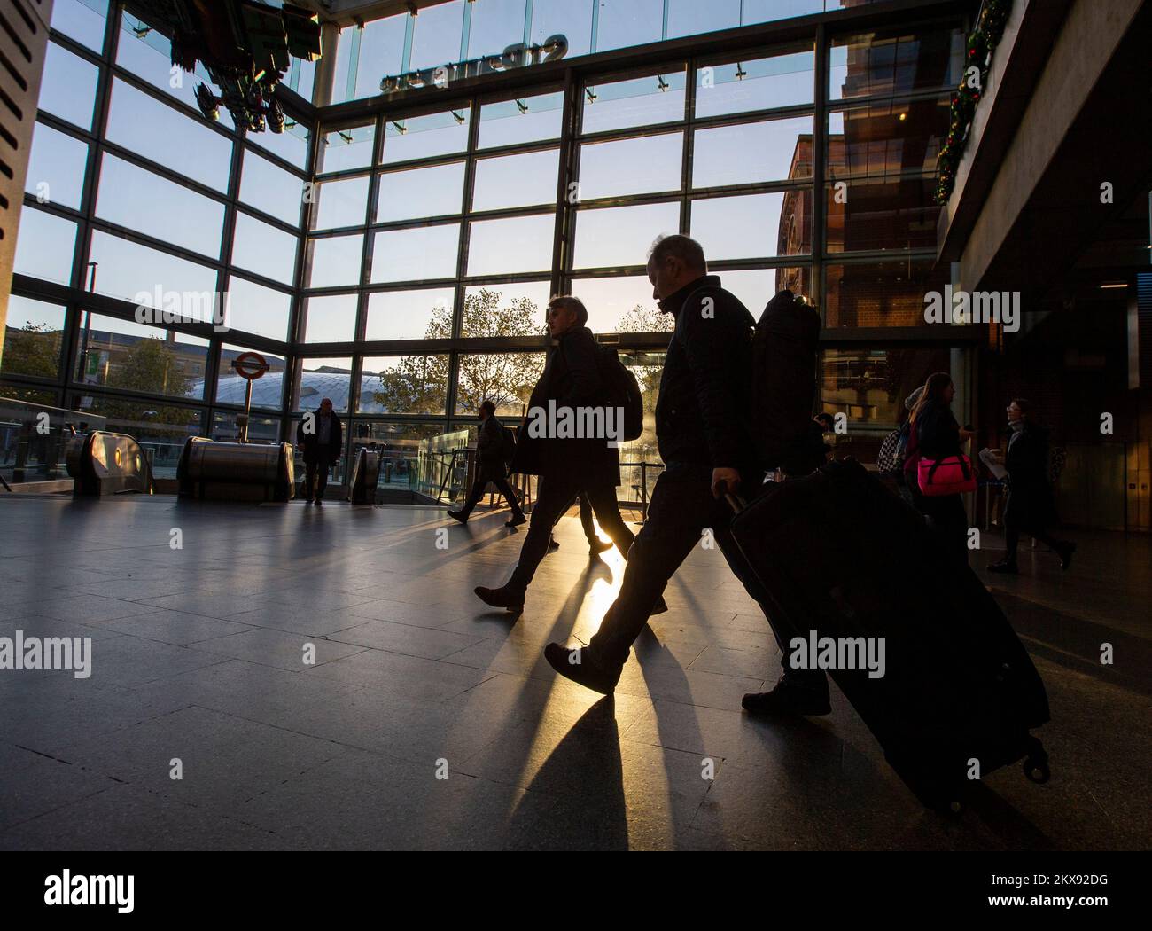 Silhouetted travellers and railway passengers with bags and suitcases ...