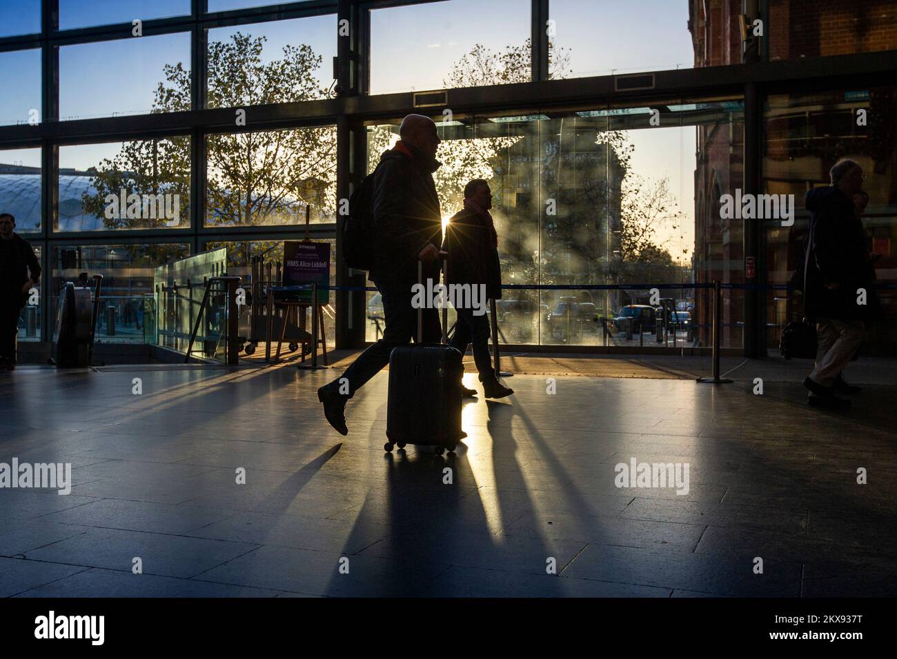 Silhouetted travellers and railway passengers with bags and suitcases ...