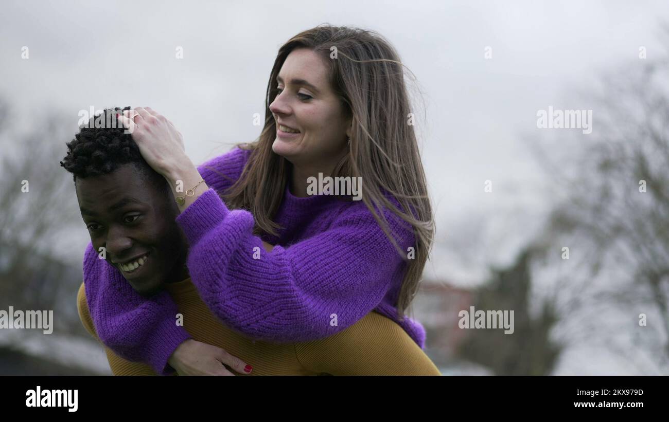 Interracial couple. Girlfriend jumping into boyfriend back2 Stock Photo ...