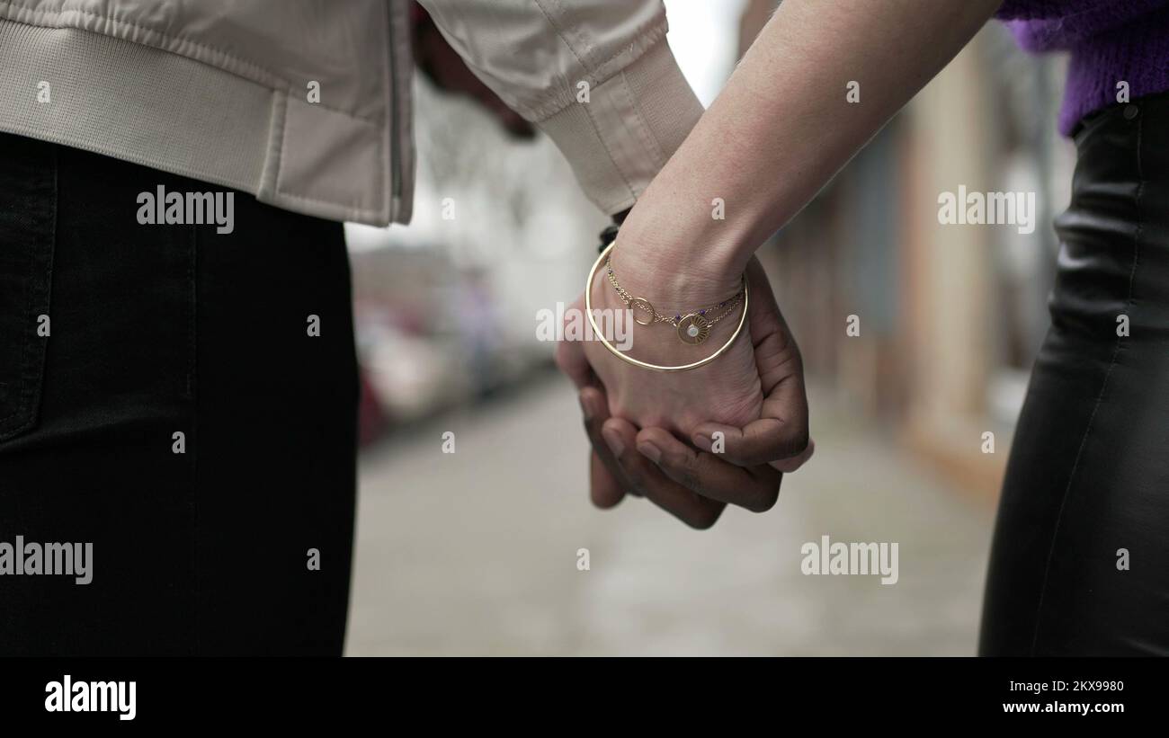 Interracial lovers holding hands together Stock Photo - Alamy