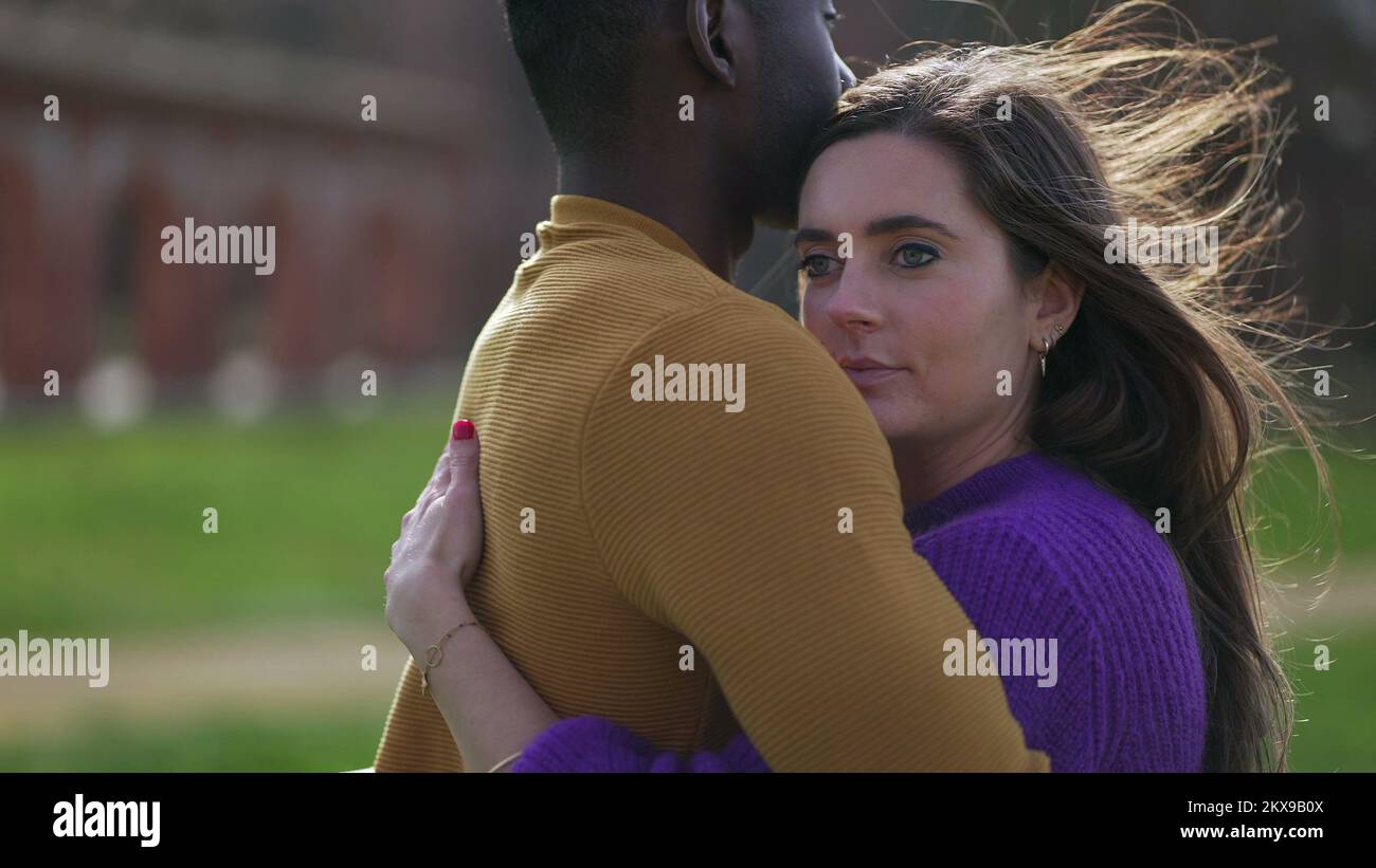 Interracial couple hugging each other outside. Young modern millennial ...