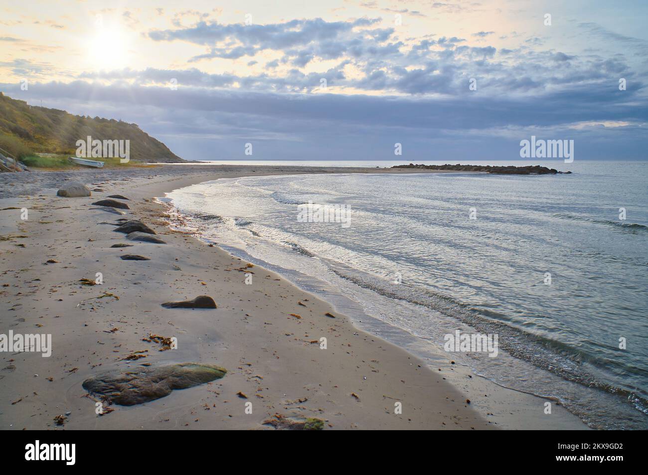 Sunset on the Danish coast. Beach, waves. Hill with trees in background ...
