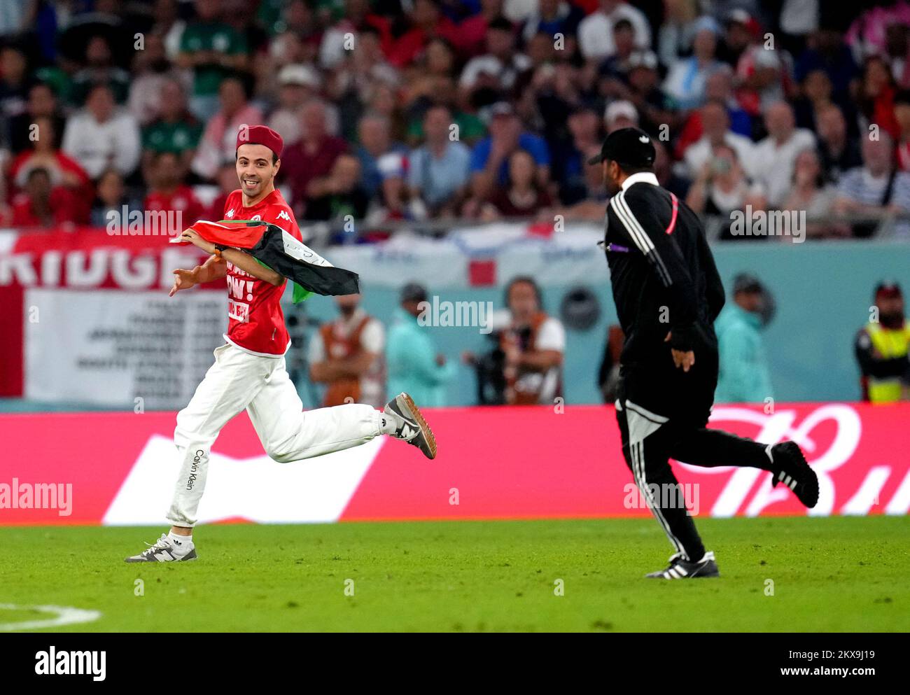A member of security chases a pitch invader during the FIFA World Cup ...
