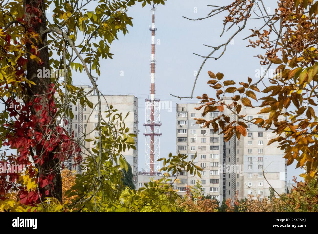 Telecommunication tower antenna on blue sky between multistory ...