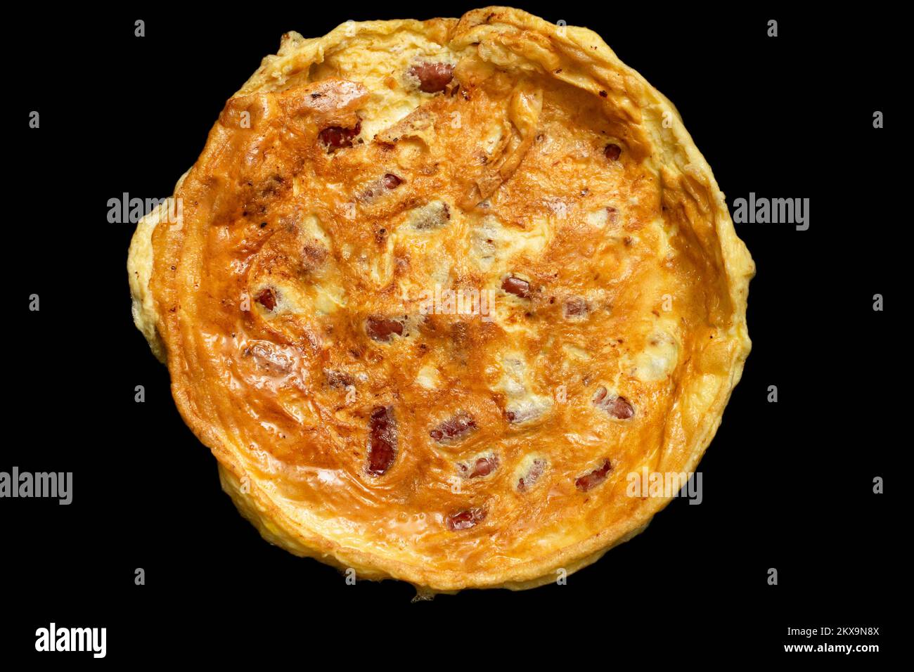 prepared round omelette with sausages, isolated on black background ...
