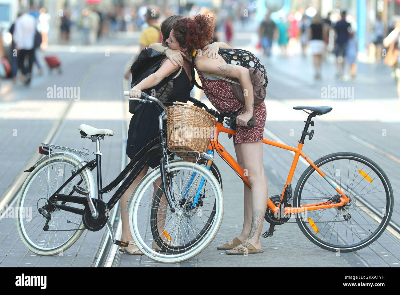 24.08.2018., Croatia, Zagreb -The charming encounter and embrace of two girls with bicycles ...