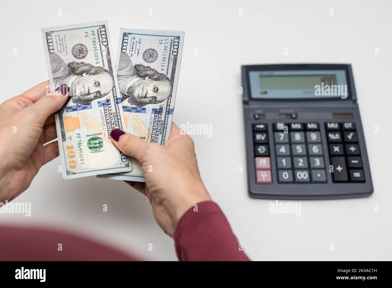 woman holding one hundred dollars in her hand. man counts his savings Stock Photo - Alamy
