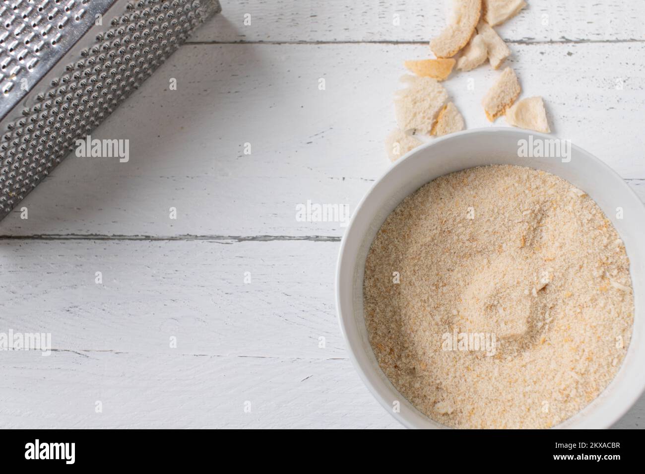 Fresh grated bread crumbs in a bowl on light background with copy space ...