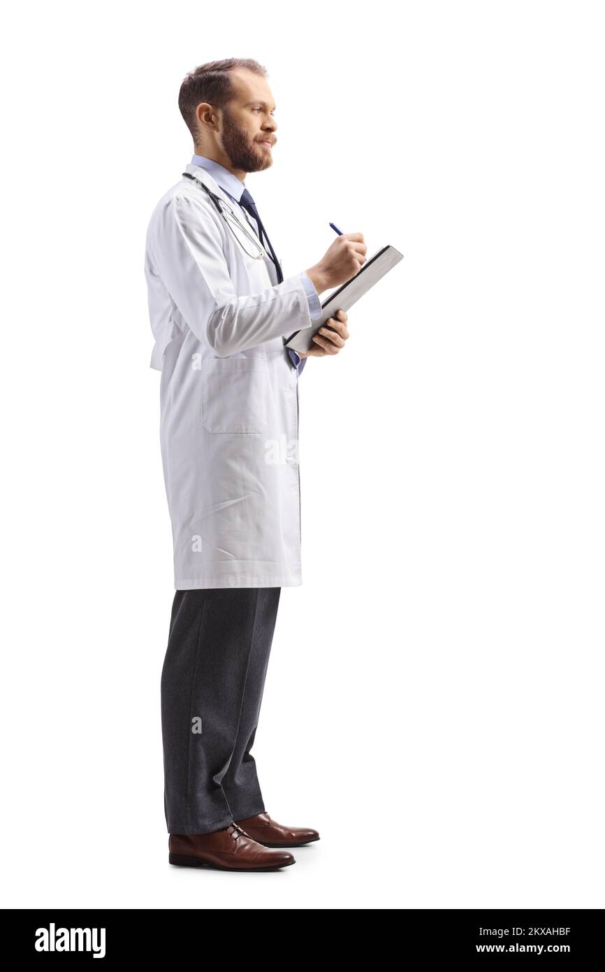 Full length profile shot of a male physician standing and writing a ...