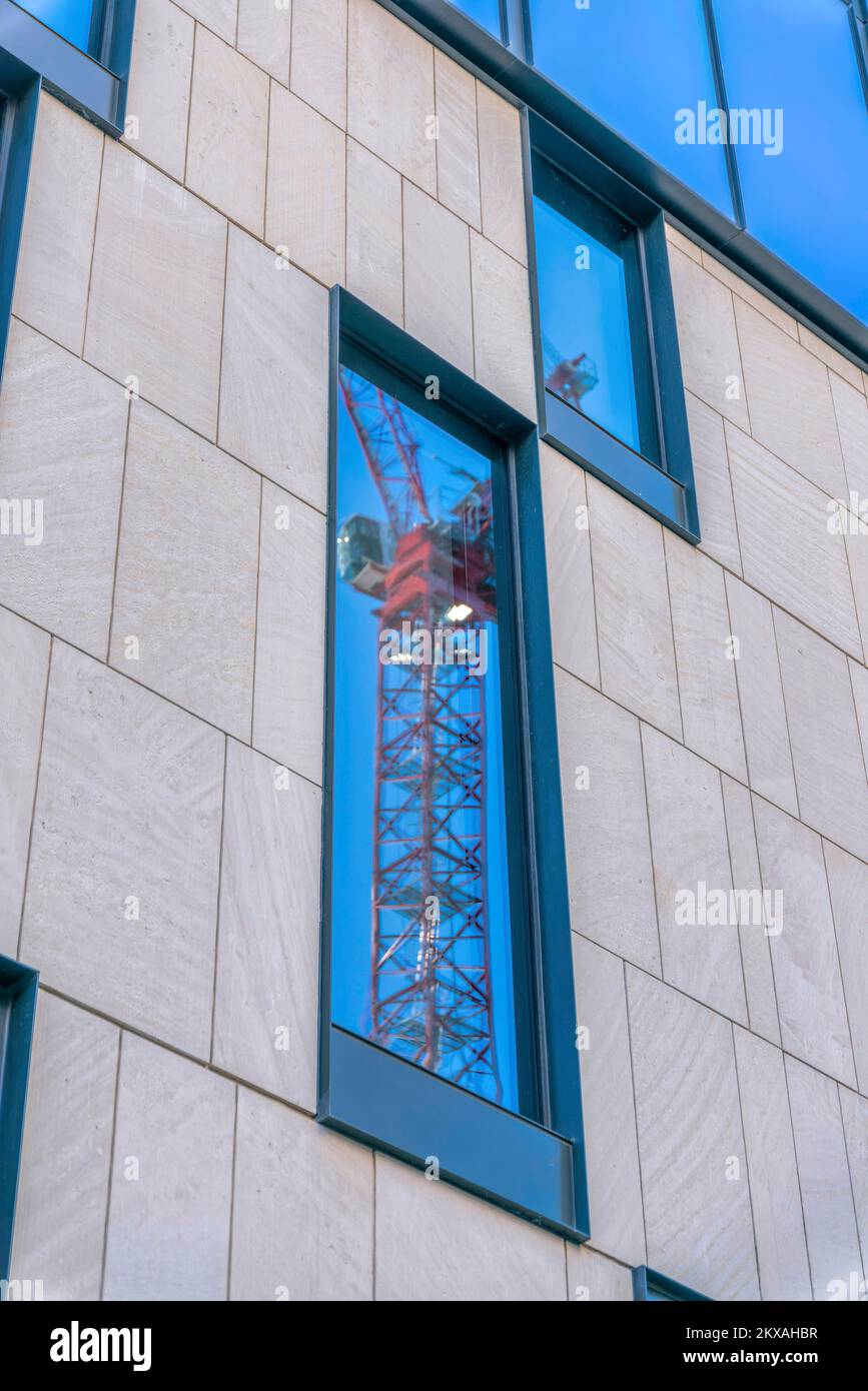 Exterior view of a building with construction crane reflected on the ...