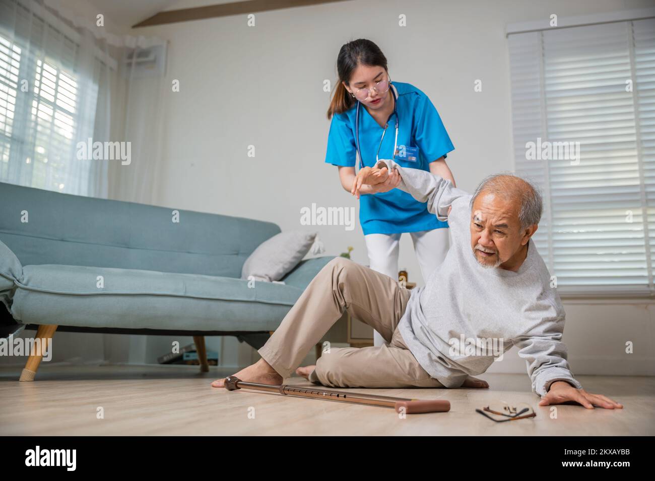 Asian older senior man falling down on lying floor and woman nurse came ...