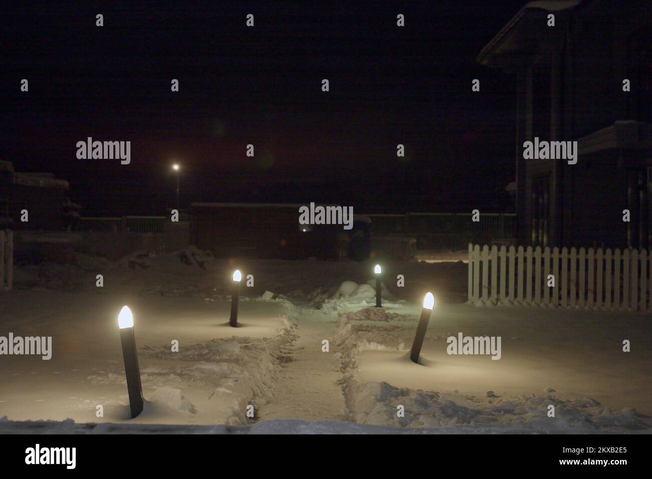 poorly lit area and a footpath in the snow, night winter scene Stock ...