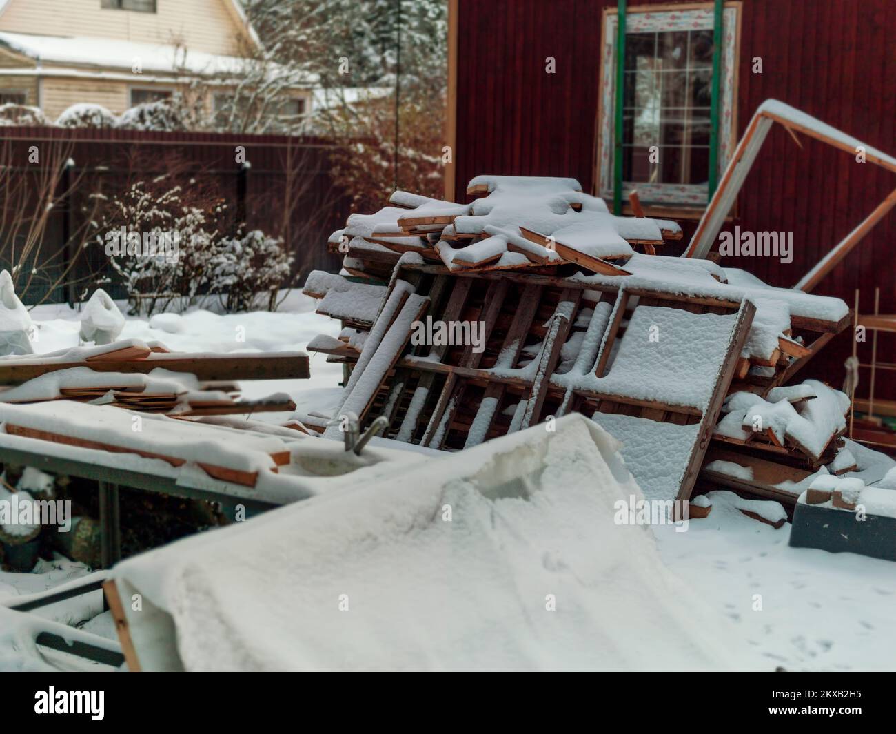 piles of junk thrown away from countryside house ands covered with snow ...