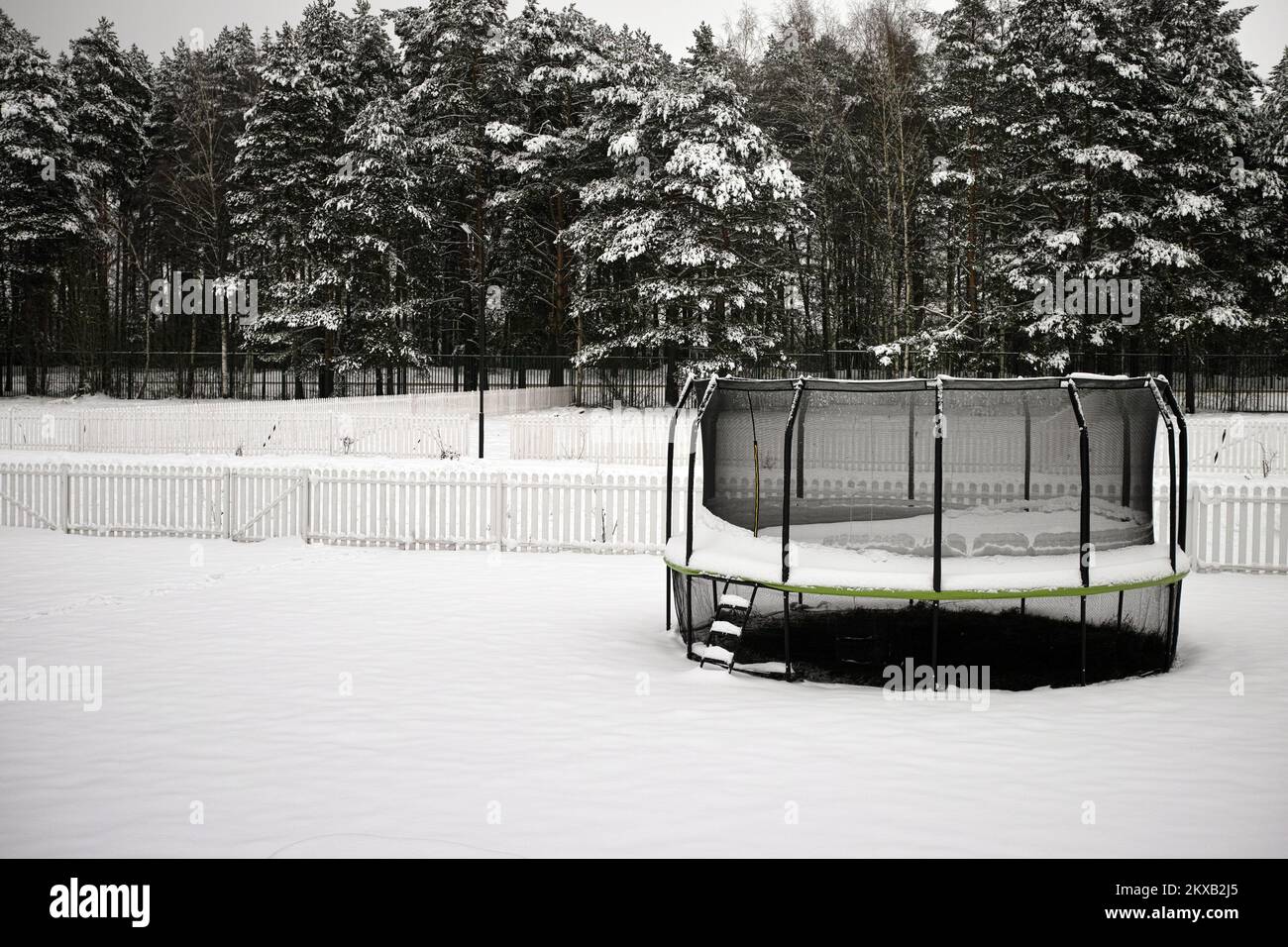 not disassembled trampoline covered with snow and abandoned on a ...