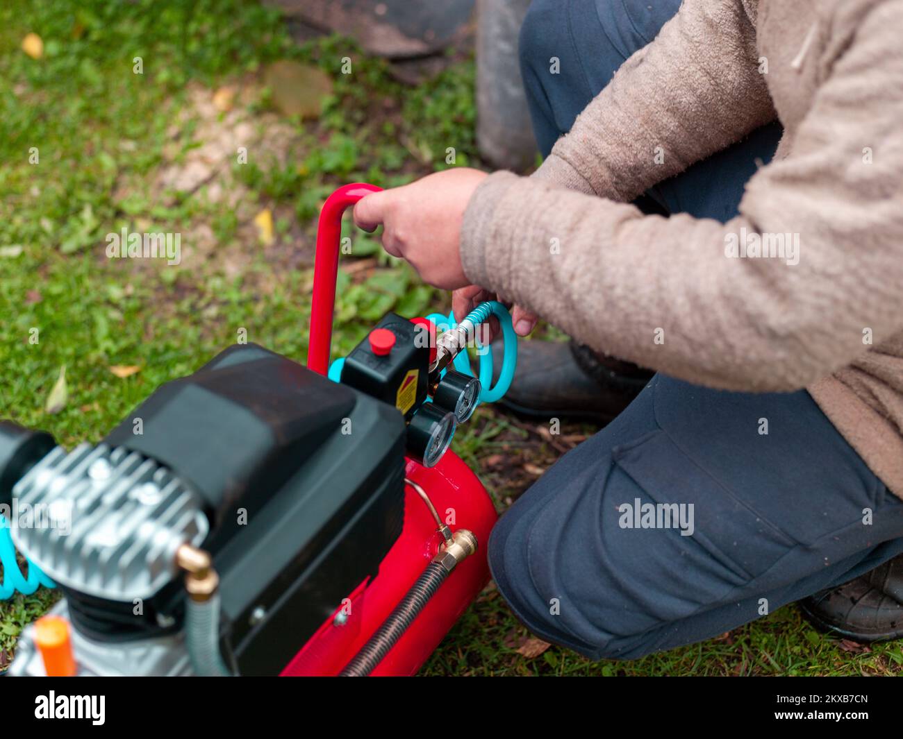 a man checking hose connection of air compressor, outdor image, shallow ...