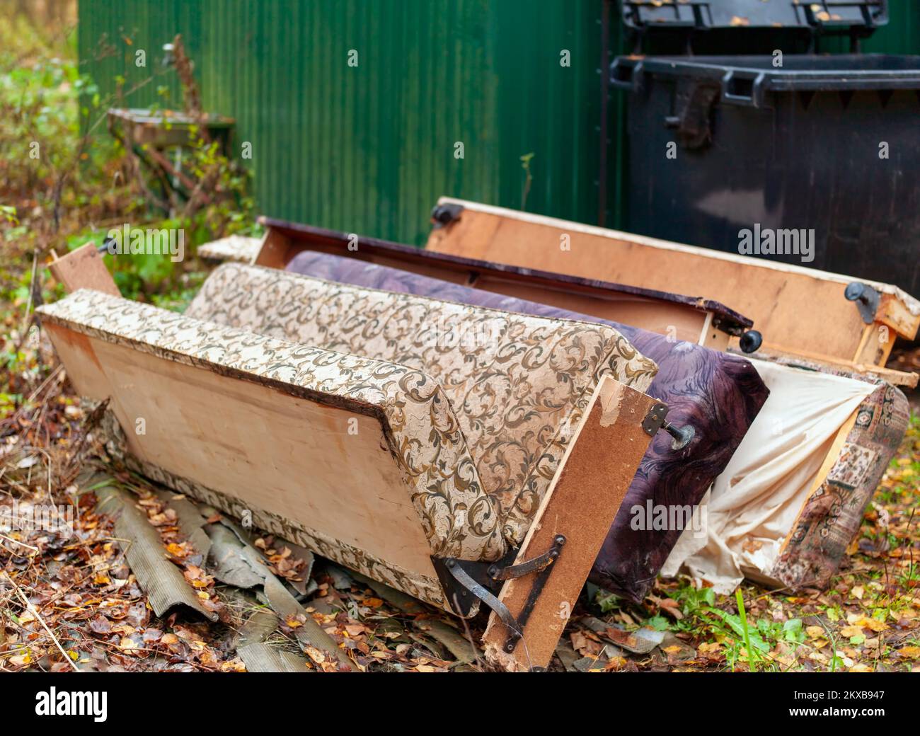 old furniture abandoned next to a garbage containers, outdoor daylight ...