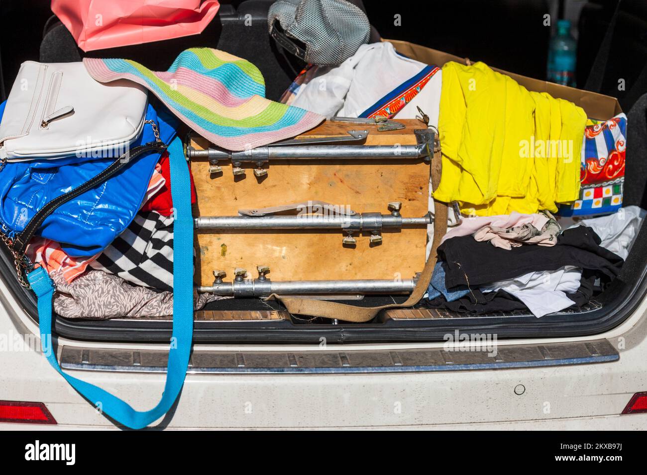 an easel and personal belongings in minivan open boot, outdoor sunny ...