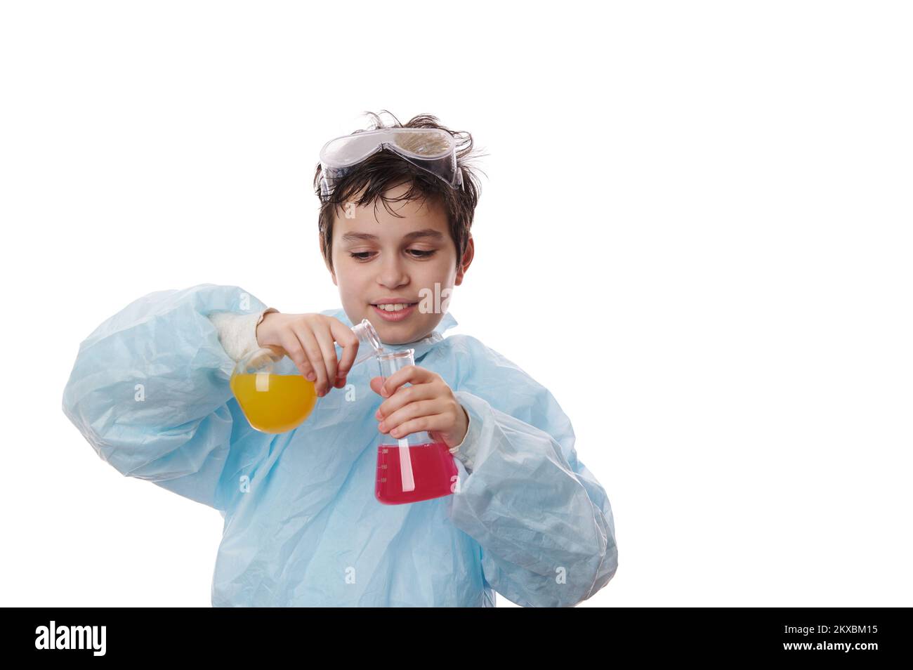 Schoolboy at chemistry class, pours solution from laboratory flask into ...