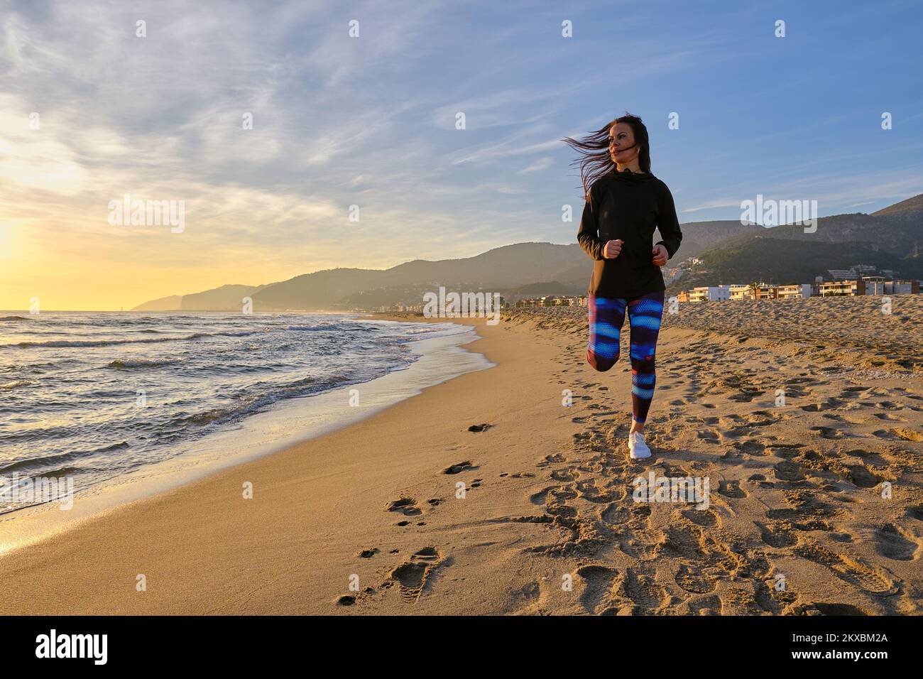 Fitness woman running along the beach Stock Photo - Alamy