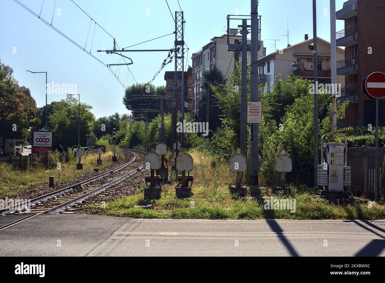 Railroad crossing with trees and buildings by its side at sunset Stock ...