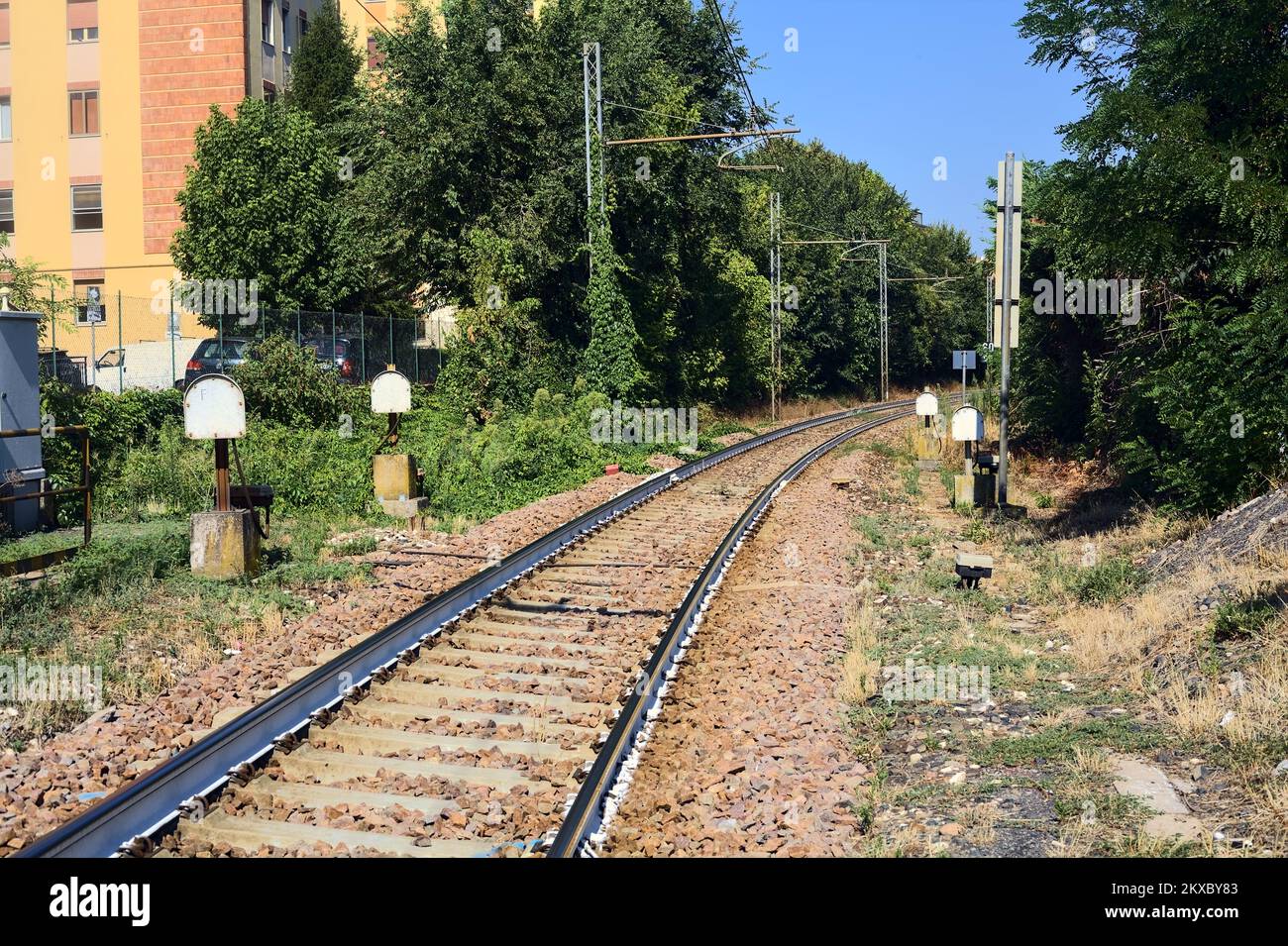 Railroad crossing with trees and buildings by its side at sunset Stock ...