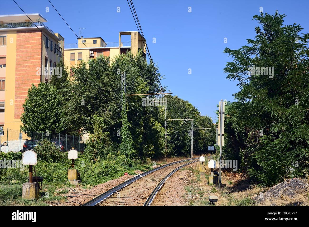 Railroad crossing with trees and buildings by its side at sunset Stock ...