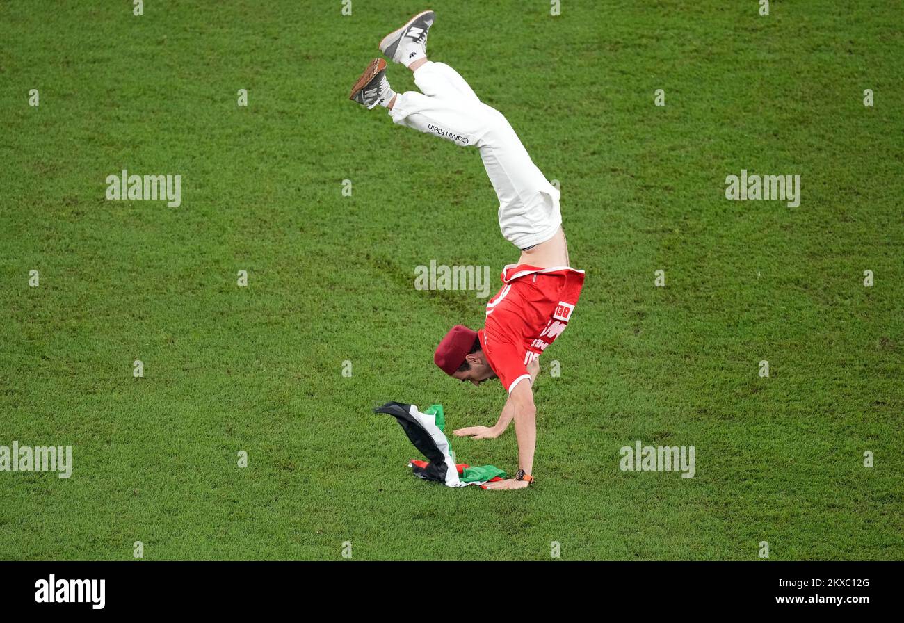 Al Rayyan, Qatar. 30th Nov, 2022. A pitch invader does a flip flop ...