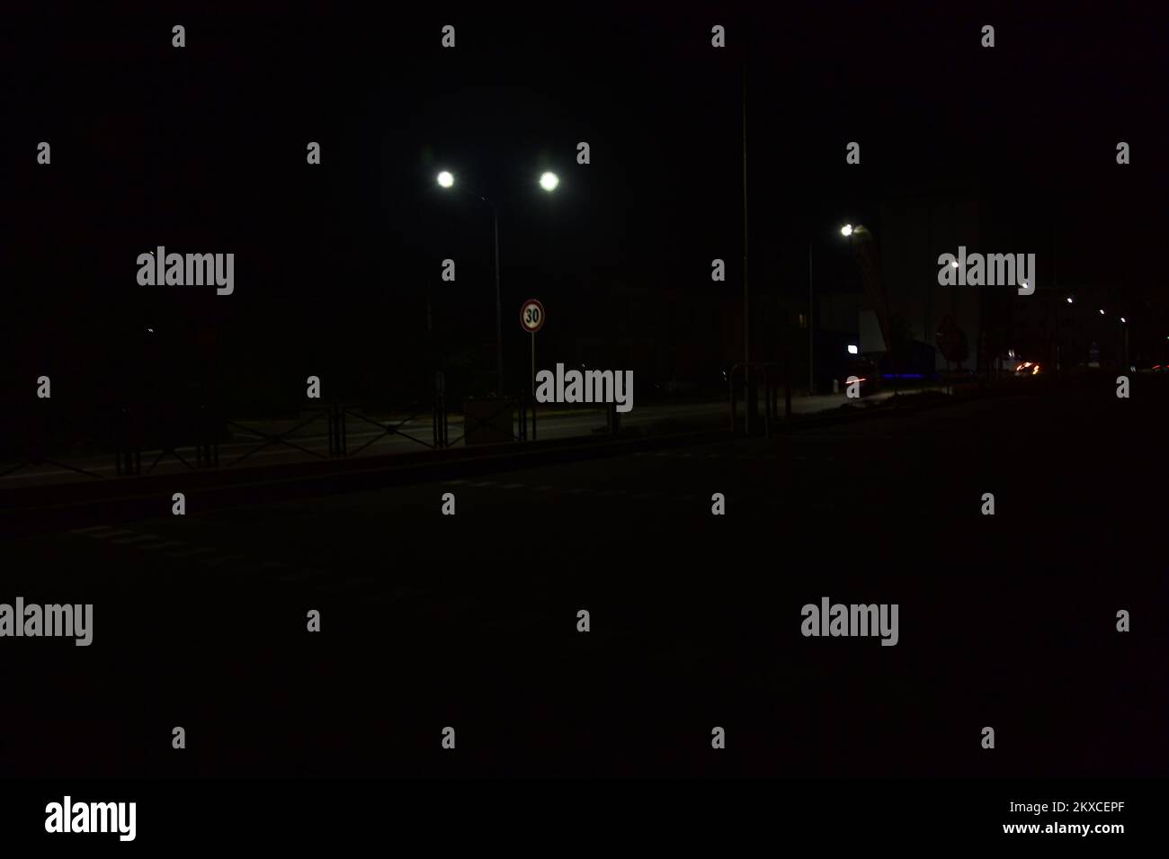 Road next to a crossing at night with cars passing by Stock Photo - Alamy