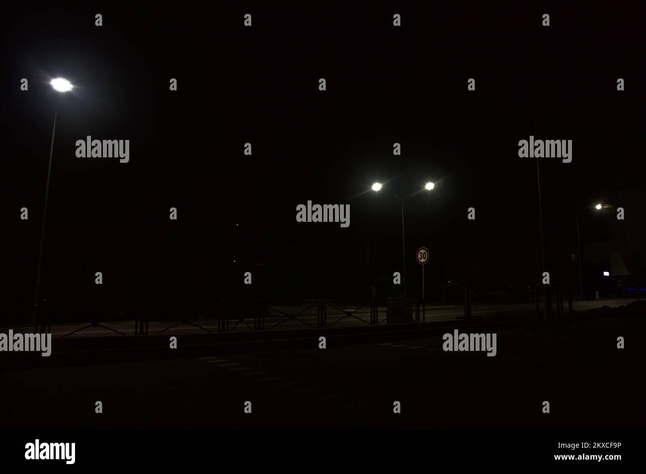 Road next to a crossing at night with cars passing by Stock Photo - Alamy