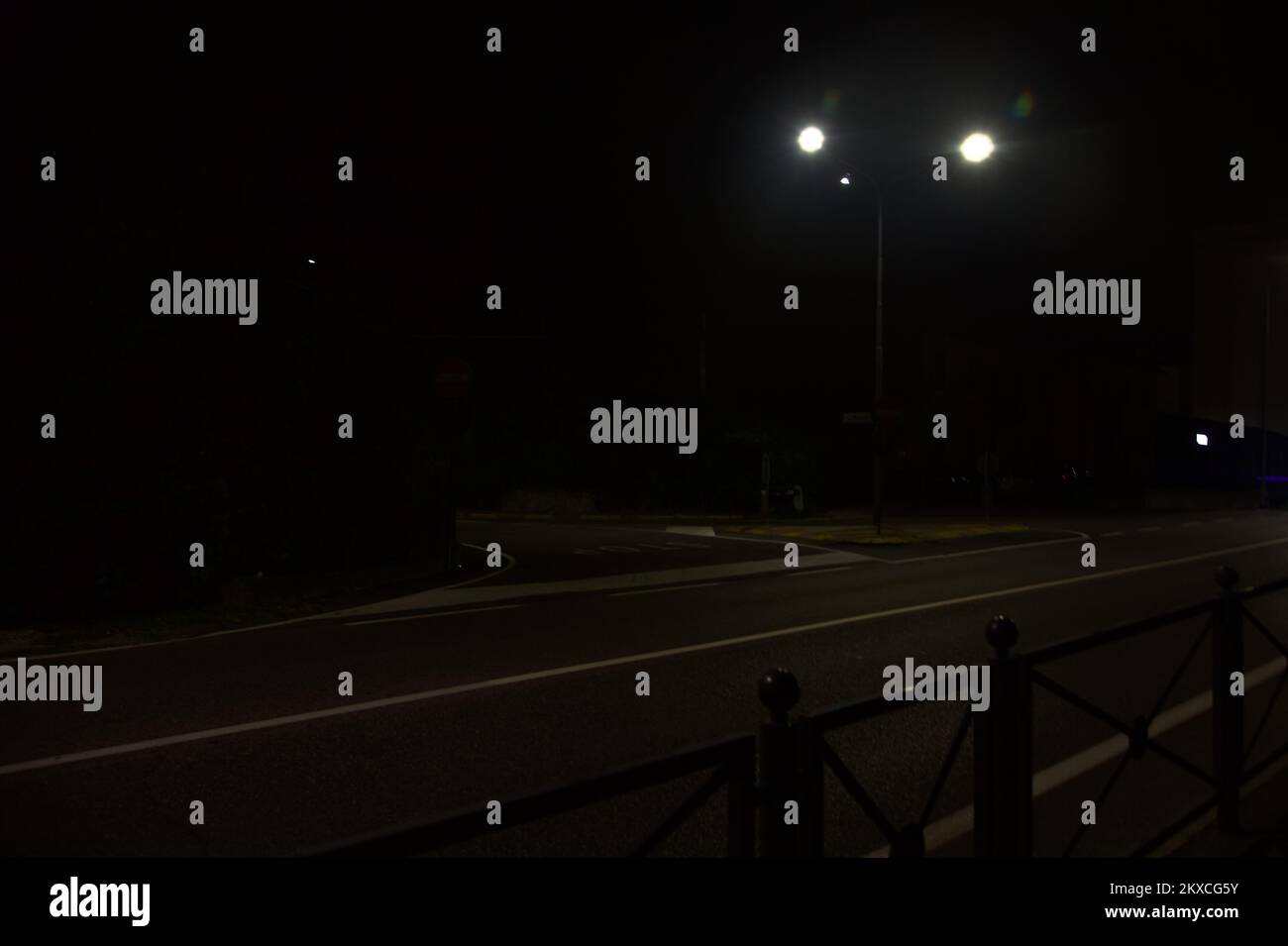 Road next to a crossing at night with cars passing by Stock Photo - Alamy