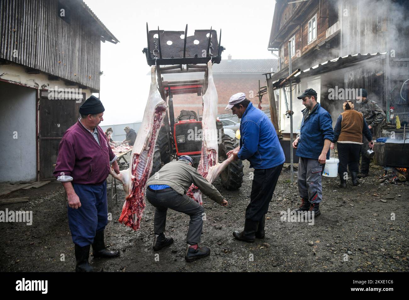 A butcher burns the skin of a slaughtered pig during a traditional pig ...